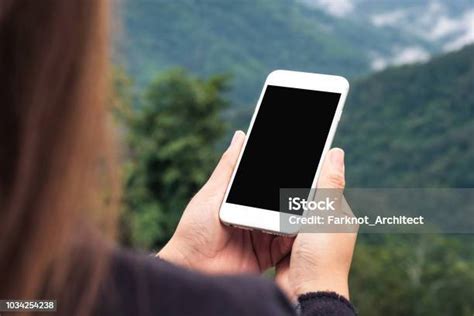 이랑 이미지에 빈 바탕 화면을 흰색 스마트폰 들고 여자의 부분 녹색 산 배경으로 야외 공란에 대한 스톡 사진 및 기타 이미지 공란 디지털 뷰파인더 만짐 Istock