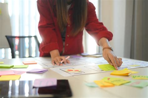 브레인스토밍 세션에서 앱 레이아웃과 인터페이스 와이어프레임에 대해 논의하는 디자이너의 모습 25 29세에 대한 스톡 사진 및 기타 이미지 25 29세 Brand