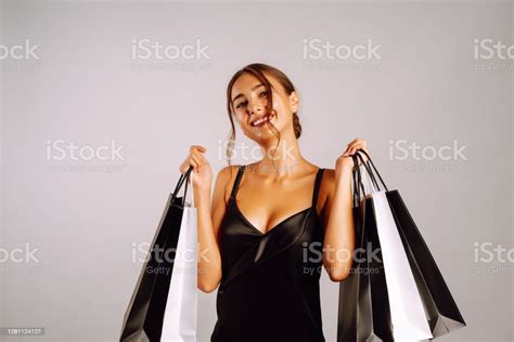 쇼핑백을 들고 회색 벽 배경에 고립 포즈를 취하는 아름다운 감정적 인 젊은 여성의 초상화 20 24세에 대한 스톡 사진 및 기타 이미지 20 24세 가방 검은색