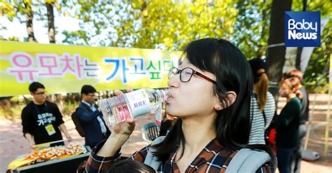 유모차 걷기대회 참석한 육아맘 아이 안고 물 한 모금