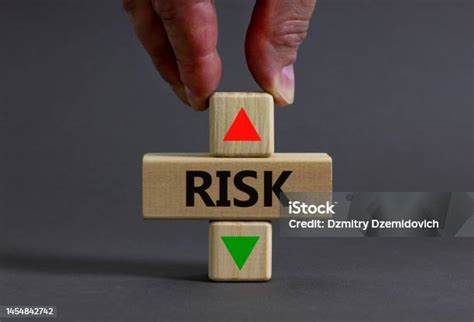 위험 수준 기호입니다 사업가는 아이콘이 있는 나무 큐브를 들고 있다 개념 단어 위험과 나무 블록 아름 다운 회색 테이블 회색