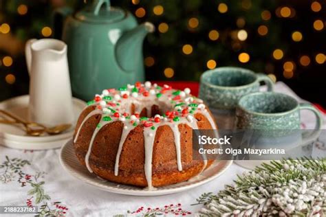 크리스마스 스프링클과 가루 설탕 아이싱을 곁들인 번트 케이크가 있는 축제 테이블 찻주전자와 머그잔 배경에 새해 나무 0명에 대한 스톡 사진 및 기타 이미지 Istock