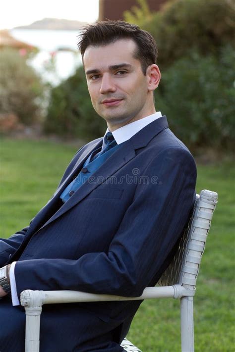 Young Man In Suit Sitting Outdoors Stock Image Image Of Attractive