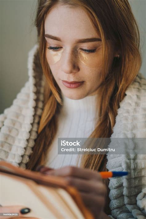 따뜻한 담요로 덮인 눈 밑 패치를 입은 여성의 초상화는 주말을 즐기며 메모를 하고 있습니다 엔터테인먼트와 레저의 개념 20 24세에 대한 스톡 사진 및 기타 이미지 Istock