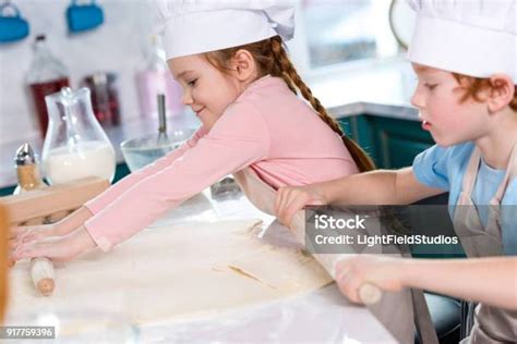 요리사 모자와 앞치마 주방에 반죽을 압 연에서 귀여운 어린 자녀 들의 모습 가정 생활에 대한 스톡 사진 및 기타 이미지 가정 생활 가정 주방 가정의 방 Istock
