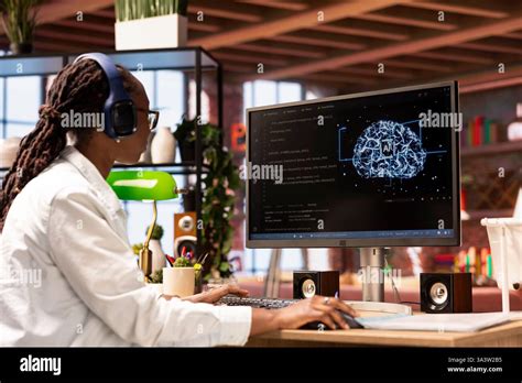 Programmer Wearing Headphones Using Computer At Home For Artificial