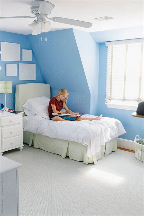 Blond Girl Doing Homework At Home By Stocksy Contributor Raymond Forbes LLC Stocksy