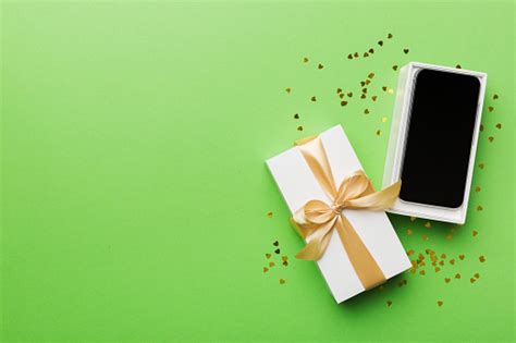 골드 리본과 스마트폰이 있는 기프트 박스를 컬러 배경 상단 보기로 오픈했습니다 빈 오픈 박스 포장 모형 디자인템플릿 브랜딩 모형 1위에 대한 스톡 사진 및 기타 이미지