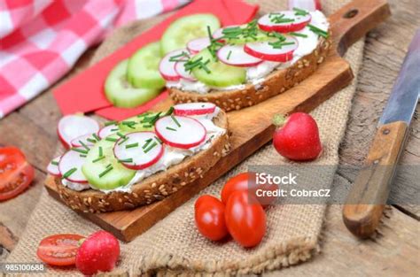 두 부 치즈 신선한 무 오이 토마토와 칼 나무 절단 보드피트 니스 건강 한 아침 식사 또는 간식의 개념에 통 밀 곡물 빵 무에
