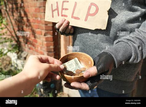 Woman Giving Money To Poor Homeless Man With Help Sign Outdoors Closeup Charity And Donation