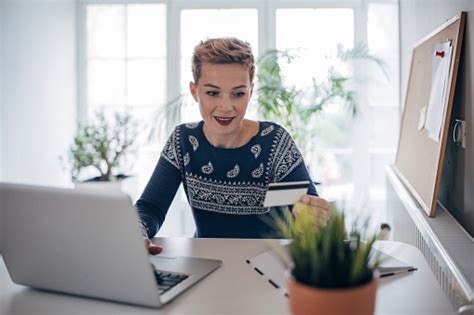 사무실에서 일하고 신용 카드를 사용하여 노트북에서 온라인 쇼핑을 하는 여성 구매에 대한 스톡 사진 및 기타 이미지 구매