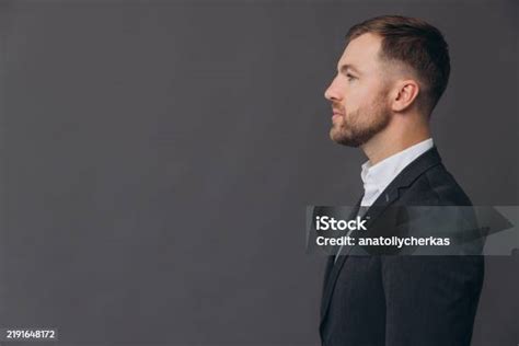 회색 스튜디오 배경에 고립 된 백인 밀레니엄 세대 사업가 포즈 정장 양복을 입고 만족한 성공한 남자가 프로필에 서 있습니다 30 34세에 대한 스톡 사진 및 기타 이미지