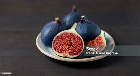 어두운 배경에 흰색 접시에 신선한 무화과 공간을 복사합니다 보라색 잘 익은 슬라이스와 전체 무화과 측면 뷰 갈색 나무 배경에 무화과 0명에 대한 스톡 사진 및 기타 이미지