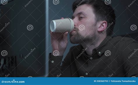 a male programmer works late at the computer in the office rubbing his