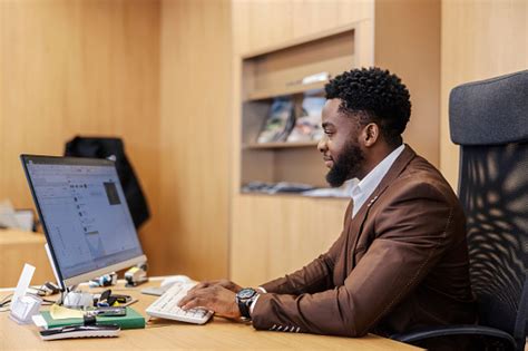 아프리카계 미국인 자동차 판매자가 사무실에 앉아서 컴퓨터에 계약서를 입력하는 모습 자동차 판매원에 대한 스톡 사진 및 기타 이미지 자동차 판매원 컴퓨터 거래자