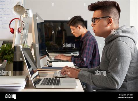 Group Of Talented Young Programmers Sitting At Spacious Open Plan