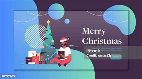 남자 들고 선물 상자 메리 크리스마스 행복 한 새해 축 하 개념 아프리카 계 미국인 남자 를 입고 산타 모자 를 입고 산타 모자 근처 앉아 플랫 전체 길이 복사 공간 수평