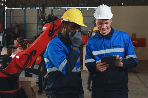 전문 중공업 기술자 엔지니어가 컴퓨터와 워키토키를 갖춘 지능형 공장에서 로봇 팔 기계의 유지 보수 및 점검 부분 산업 및 기술 지원 시스템 개념 25 29세에 대한 스톡