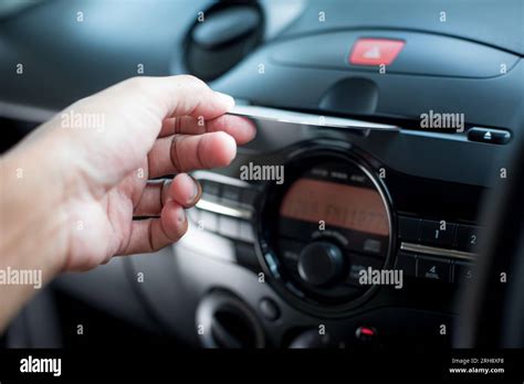 the man inserting cd to cd player in the car car audio system concept