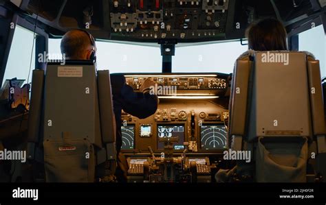 captain and woman copilot in cockpit preparing to fly airplane using