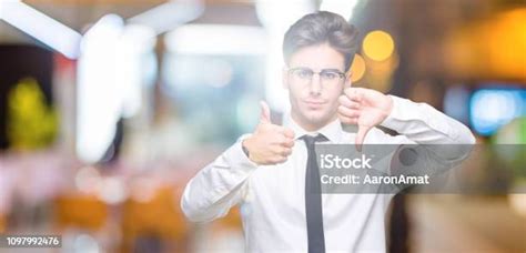 격리 된 배경 하 고 엄지손가락 위에 아래로 안경을 하는 젊은 사업가 불일치 및 계약 식 미친 충돌 개념에 대한 스톡 사진 및 기타 이미지 Istock