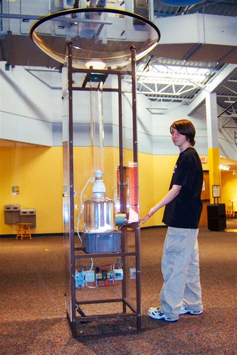 A Babe Man Standing Next To A Large Metal Object