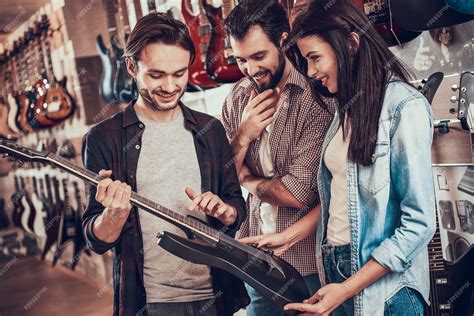 Vendedor De Instrumentos Musicales Muestra Guitarra Para Compradores