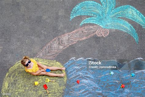 바다 모래 아스팔트에 화려한 분필로 칠해진 손바닥으로 수영복을 입은 행복한 어린 미취학 소녀 분필 그림으로 재미있게 지내는 귀여운 아이 여름 휴가 여름 분필에 대한 스톡