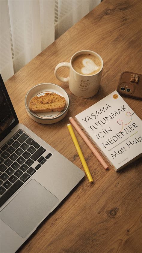 나무 책상 위에 커피와 책이 있는 아늑한 작업 공간 · 무료 스톡 사진