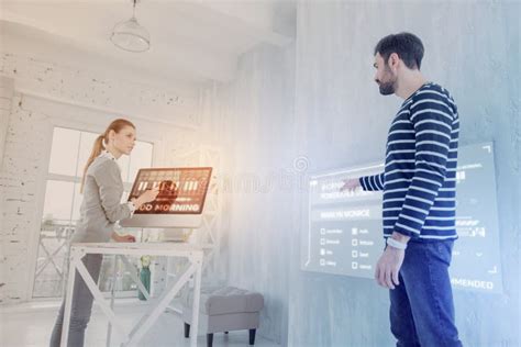 Clever Programmer Pointing To The Screen While Talking To His Colleague