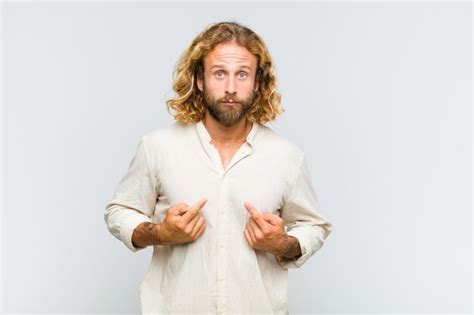 Premium Photo Blonde Man Pointing To Self With A Confused And Quizzical Look Shocked And