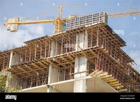 Building Under Construction Utilizing Modern Technology And Industrial Cranes Showcases An