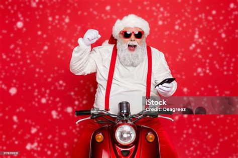 좋은 매력적인 수염 쾌활한 쾌활한 기쁜 재미 펑키 산타 모자를 쓰고 모터 자전거에 앉아 밝은 생생한 광택 생생한 붉은 색 배경 위에 고립 된 좋은 소식 35 39세에 대한