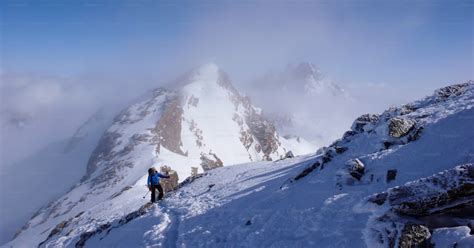 옅은 안개 속에서 바위와 눈 능선을 따라 스위스의 높은 고산 정상으로 하이킹하는 남성 오지 스키 선수 사진 Unsplash의 눈사태 이미지