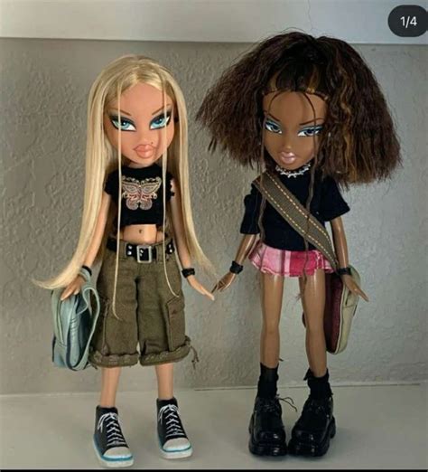 Two Dolls Standing Next To Each Other Holding Hands