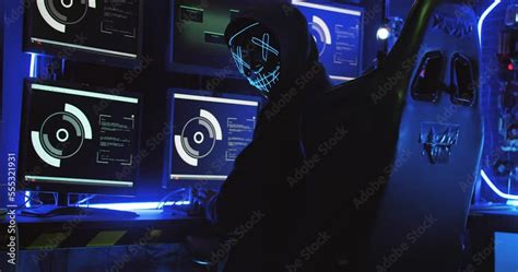 A Hacker Wearing A Mask To Cover His Face Is Using Computer To Hack