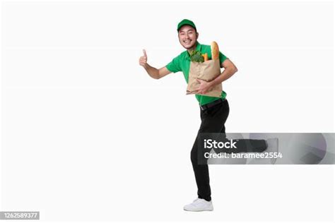 녹색 유니폼을 입은 아시아 배달 남자는 흰색 배경에 고립 된 신선한 음식 종이 가방을 들고 가방에 대한 스톡 사진 및 기타