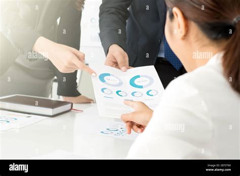 Business People Discussing And Analyzing Graph Data At The Meeting