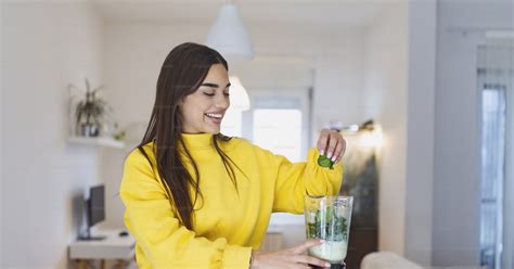 집에서 해독 스무디를 만드는 젊은 여성 과일과 채소의 스무디를 만드는 소녀 건강한 삶의 방식 믹서기를 사용하여 스무디를