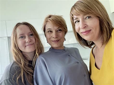 Beautiful Mature Mother And Her Daughter Making A Selfie Using Smart Phone And Smiling Indoor