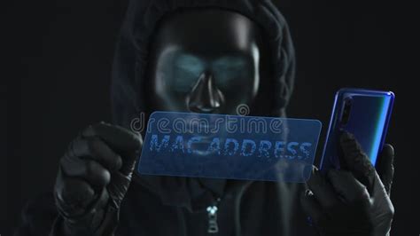 Hacker Wearing Black Mask Pulls Mac Address Tab From A Smartphone