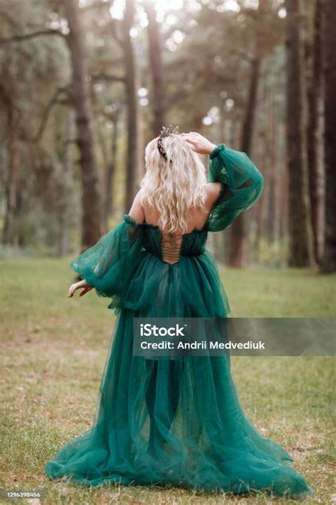 젊은 아름다운 금발 머리 여자 여왕 공주 산책 가을 녹색 숲 신비 빈티지 중세 빛나는 크라운 긴 저녁 녹색 드레스 마법의 환상