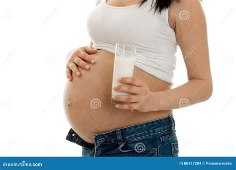 Studio Portrait Of Pregnant Woman With Glasses Of Milk In Her Hands