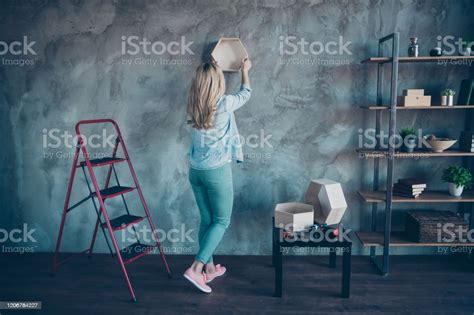 현대 산업 로프트 벽돌 스타일 인테리어 룸에서 평면 거실 공간을 장식 하는 회색 벽에 선반을 매달려 좋은 매력적인 물결 모양의 소녀의 초상화 뒤에 전체 길이 바디 크기 뒤