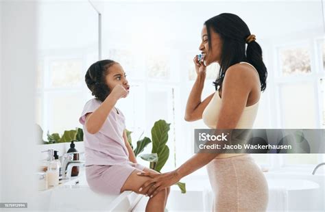Brushing Teeth Hygiene And A Mama With Her Daughter In The Bathroom Of Their Home Together For A