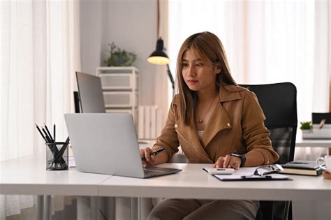 현대 사무실에서 컴퓨터 노트북으로 온라인으로 작업하는 매력적인 아시아 여성 18 19세에 대한 스톡 사진 및 기타 이미지