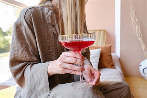 레드 와인 샴페인 또는 칵테일 한 잔을 편안한 소녀의 손에 쥐고 있습니다 알코올 음료 시음 여름 휴식 낭만적 인 저녁 아페리티프 와인 한 잔의 클로즈업 마시기에 대한 스톡