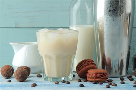 연한 파란색 배경에 유리컵에 우유와 얼음 조각이 있는 아이스 커피 상쾌한 음료 여름 음료 각얼음에 대한 스톡 사진 및 기타