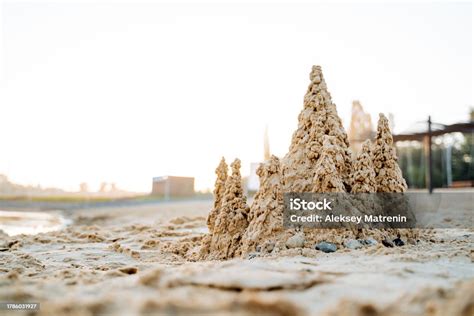 바다 해변의 모래성 젖은 모래를 가지고 노는 아이들의 즐거움 태양을 배경으로 한 모래 탑 바다의 아침 새벽 해안 휴가 0명에