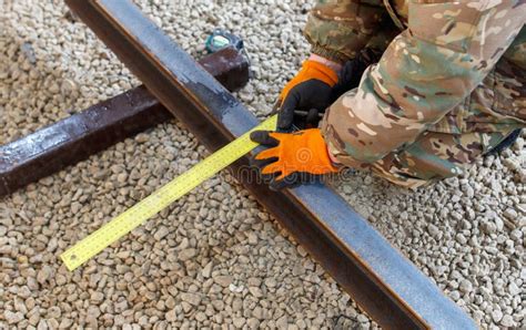 A Man In A Camo Jacket Is Measuring A Rail With A Yellow Tape Measure Stock Image Image Of
